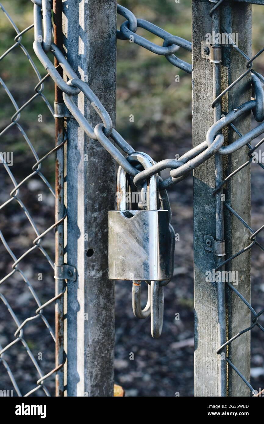 Photo of a metal padlock on a gate and fence Stock Photo - Alamy