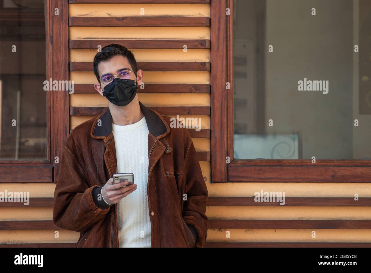 young man with mask and mobile phone outdoors Stock Photo - Alamy