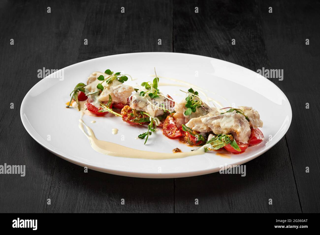 Cod fillet with tomato saute and Alfredo cream cheese sauce Stock Photo ...