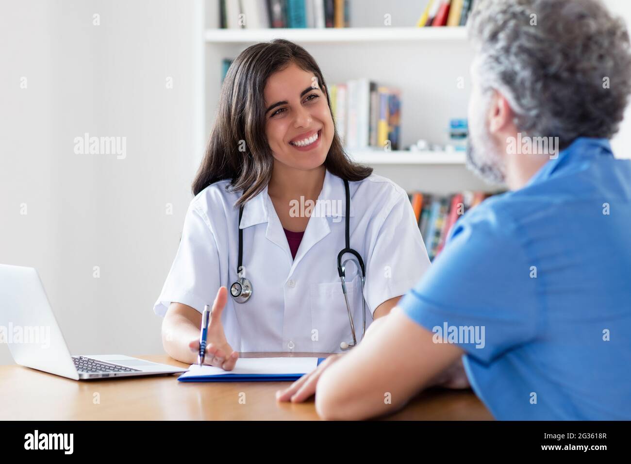 Laughing mexican female doctor talking with patient at hospital Stock ...
