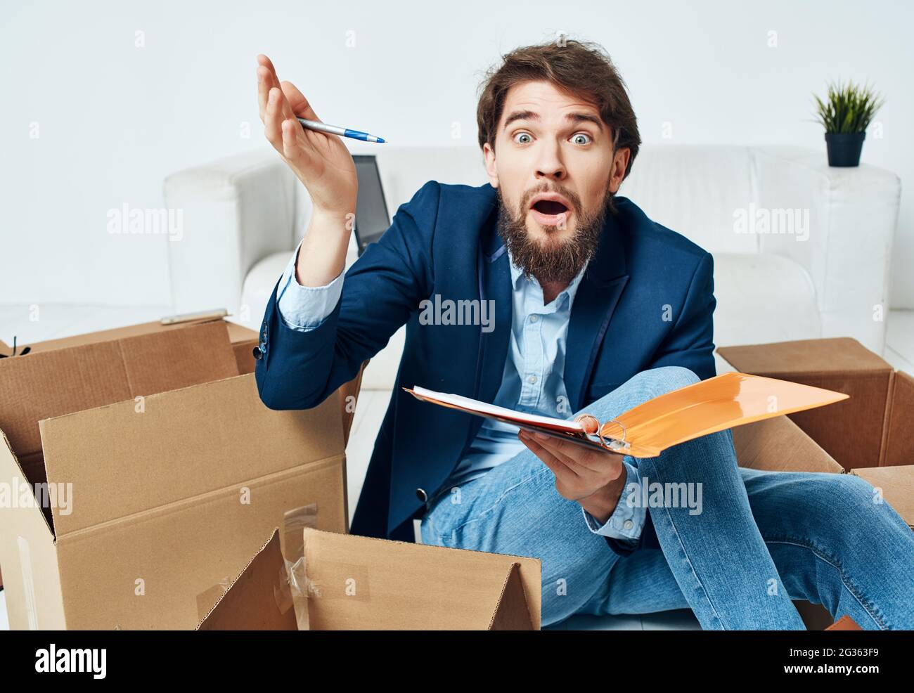 manager with cardboard boxes sitting on the floor moving things office ...