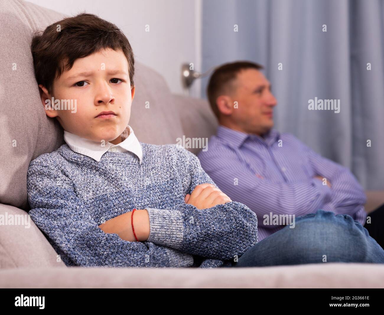 Offended son and unhappy father having quarrel in living room Stock ...