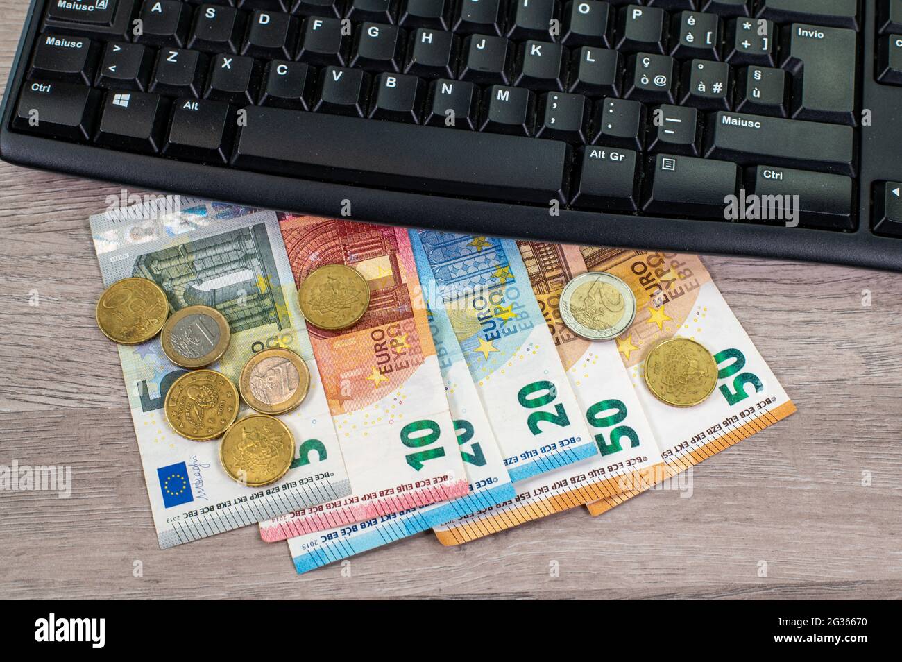 euro money of different denominations and computer keyboard on wooden ...
