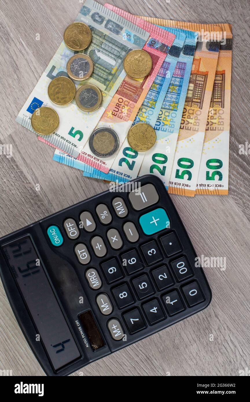 euro money of different denominations and calculator on wooden ...