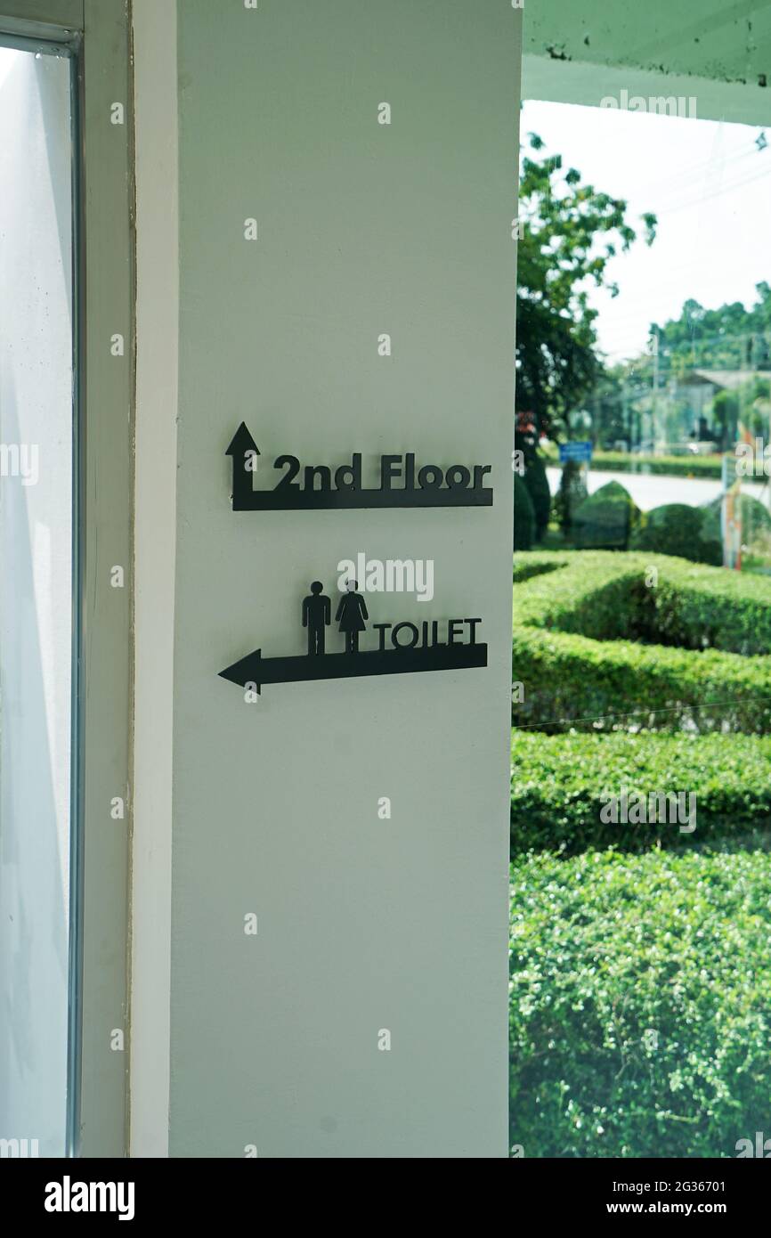 Toilet and 2nd second floor directional sign on white wall Stock Photo ...
