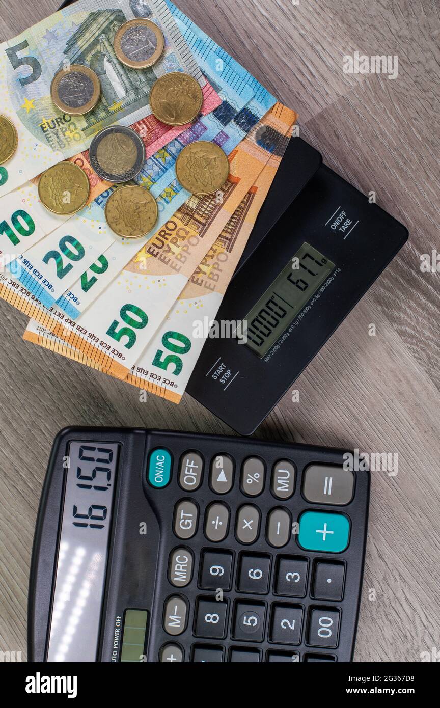 euro money of different denominations on top of a scales and calculator ...