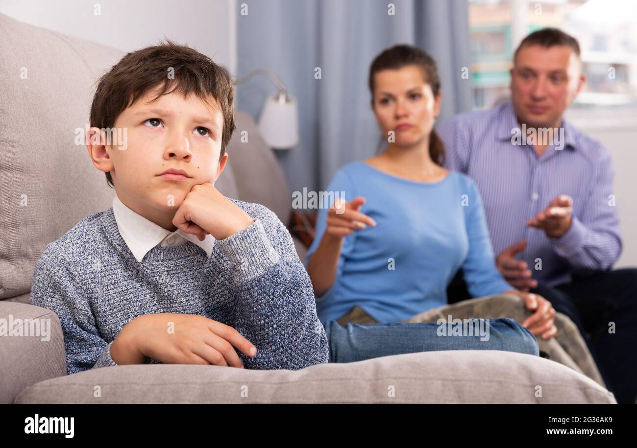 Portrait of upset boy scolded by parents at home Stock Photo - Alamy