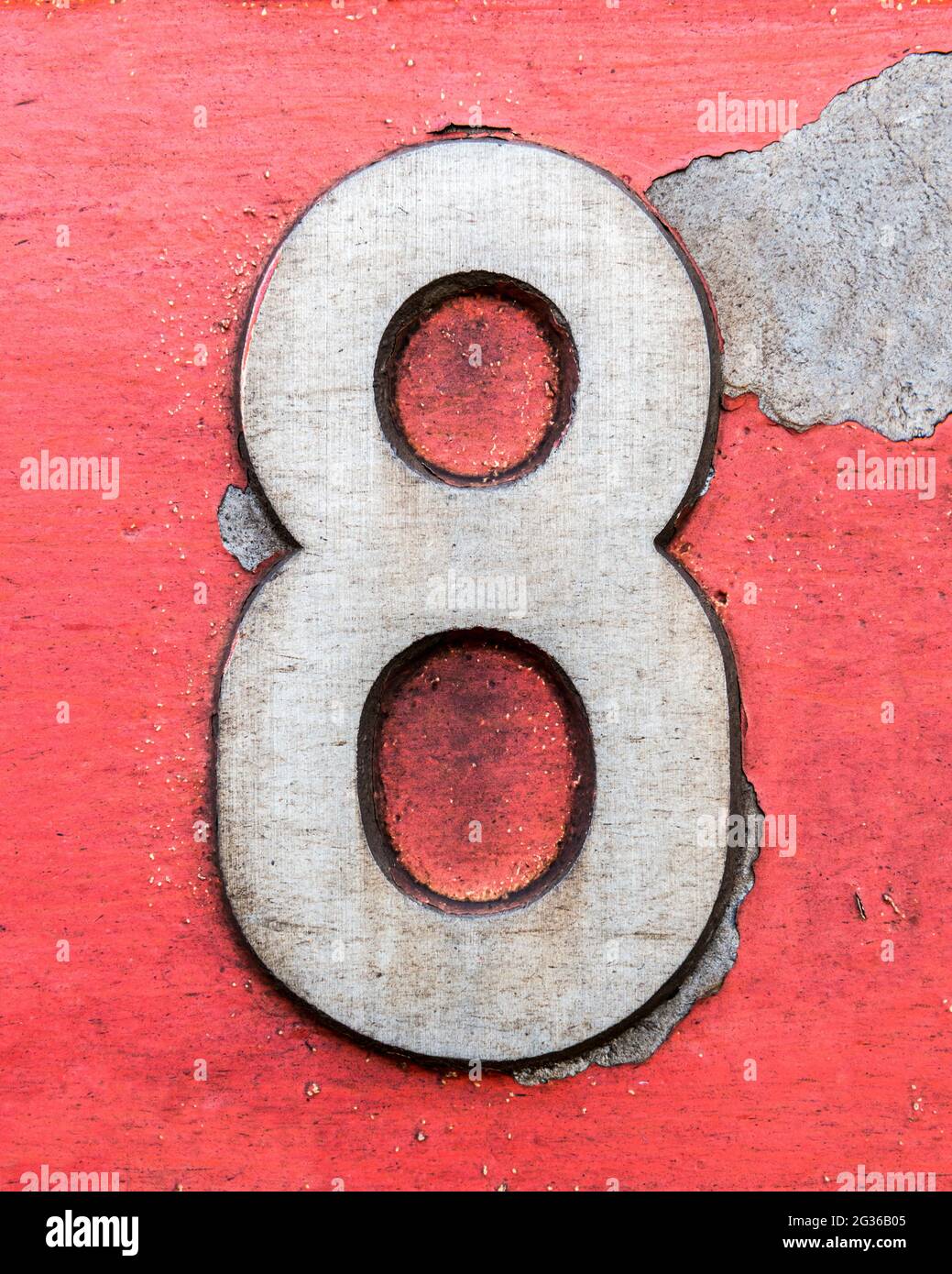 Figure 8 made of metal on red lacquered background Stock Photo - Alamy