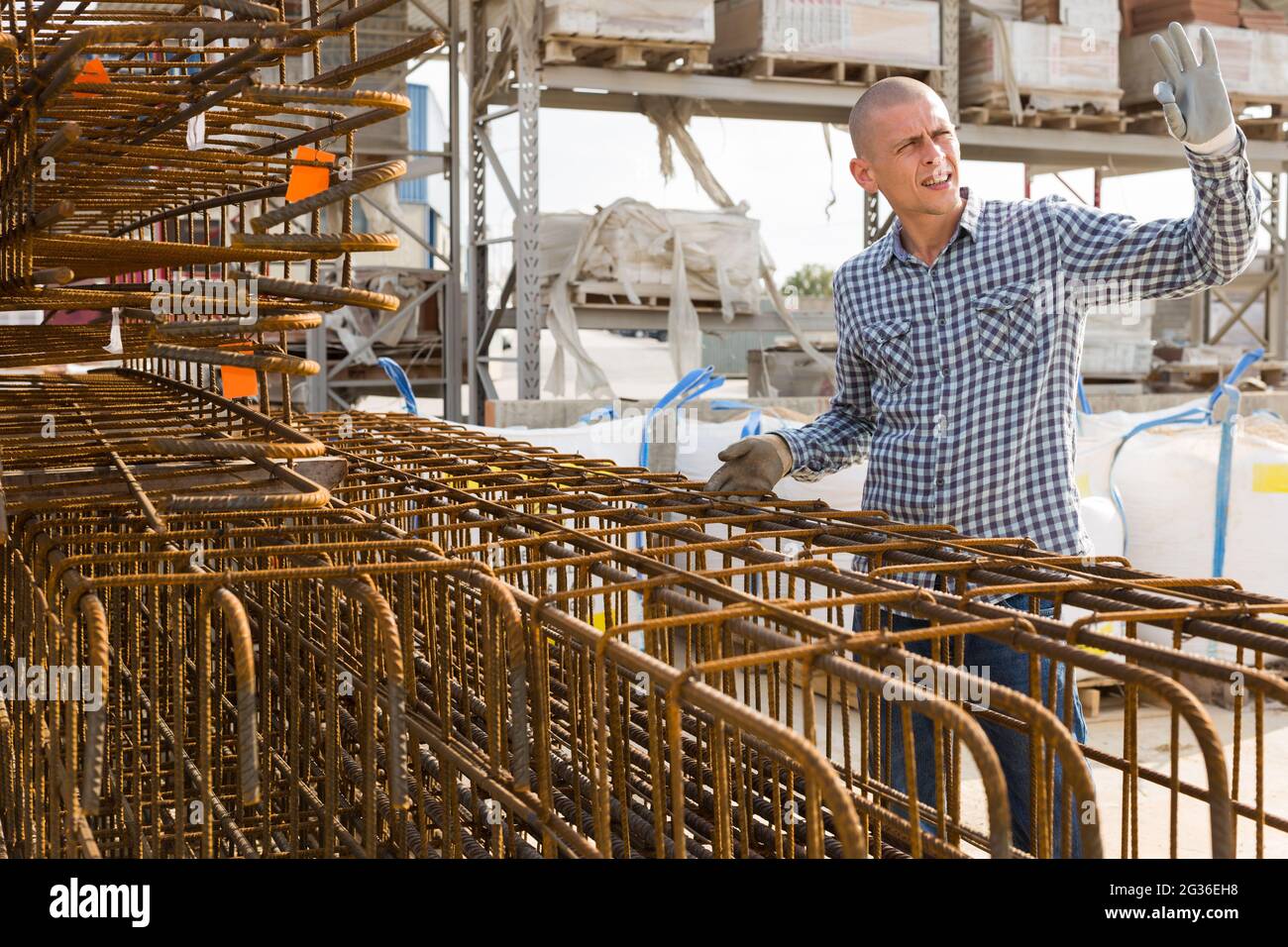 Man worker with reinforcing steel bars during work in warehouse Stock ...