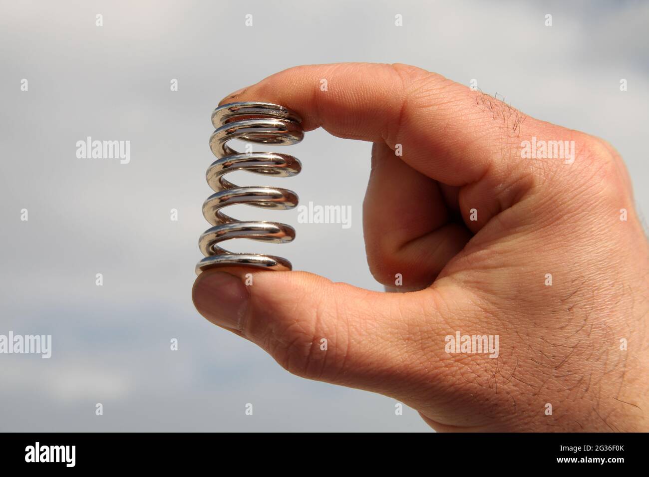 Metal spring in the hands of the engineer. Newly manufactured metal ...