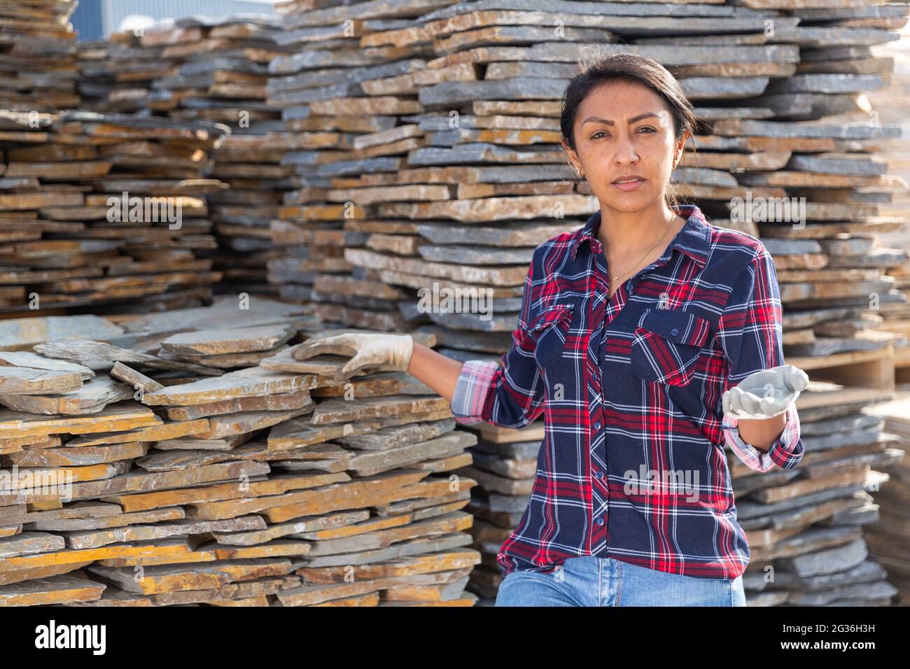 Hispanic woman worker posing with natural stone tile Stock Photo - Alamy