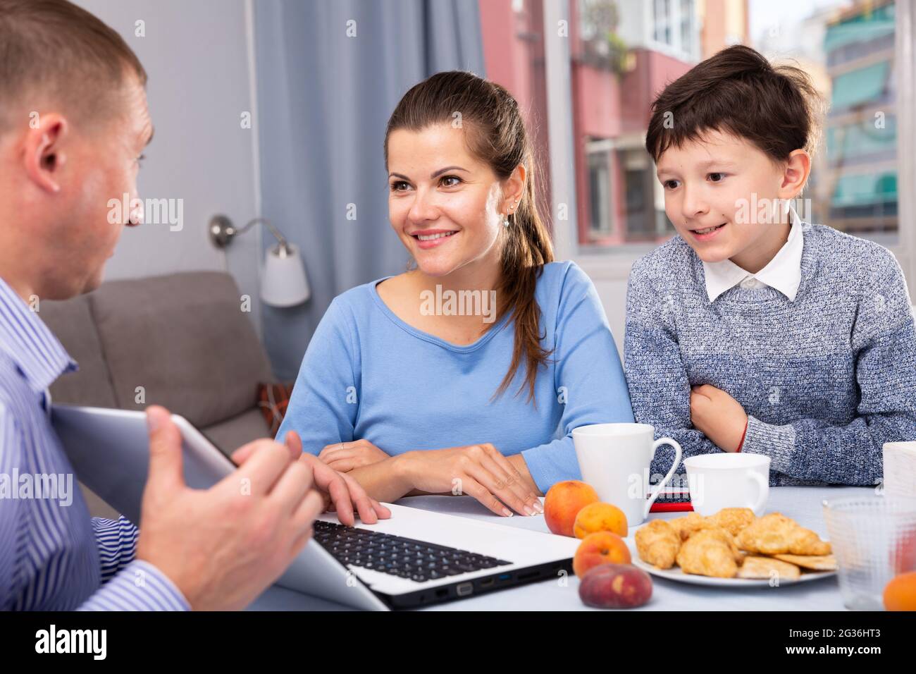 Happy family with laptop discussing their plans Stock Photo - Alamy