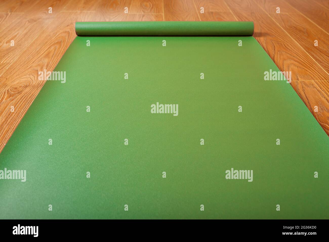 Green Yoga mat on wooden floor unfolded. Healthy lifestyle, fitness ...