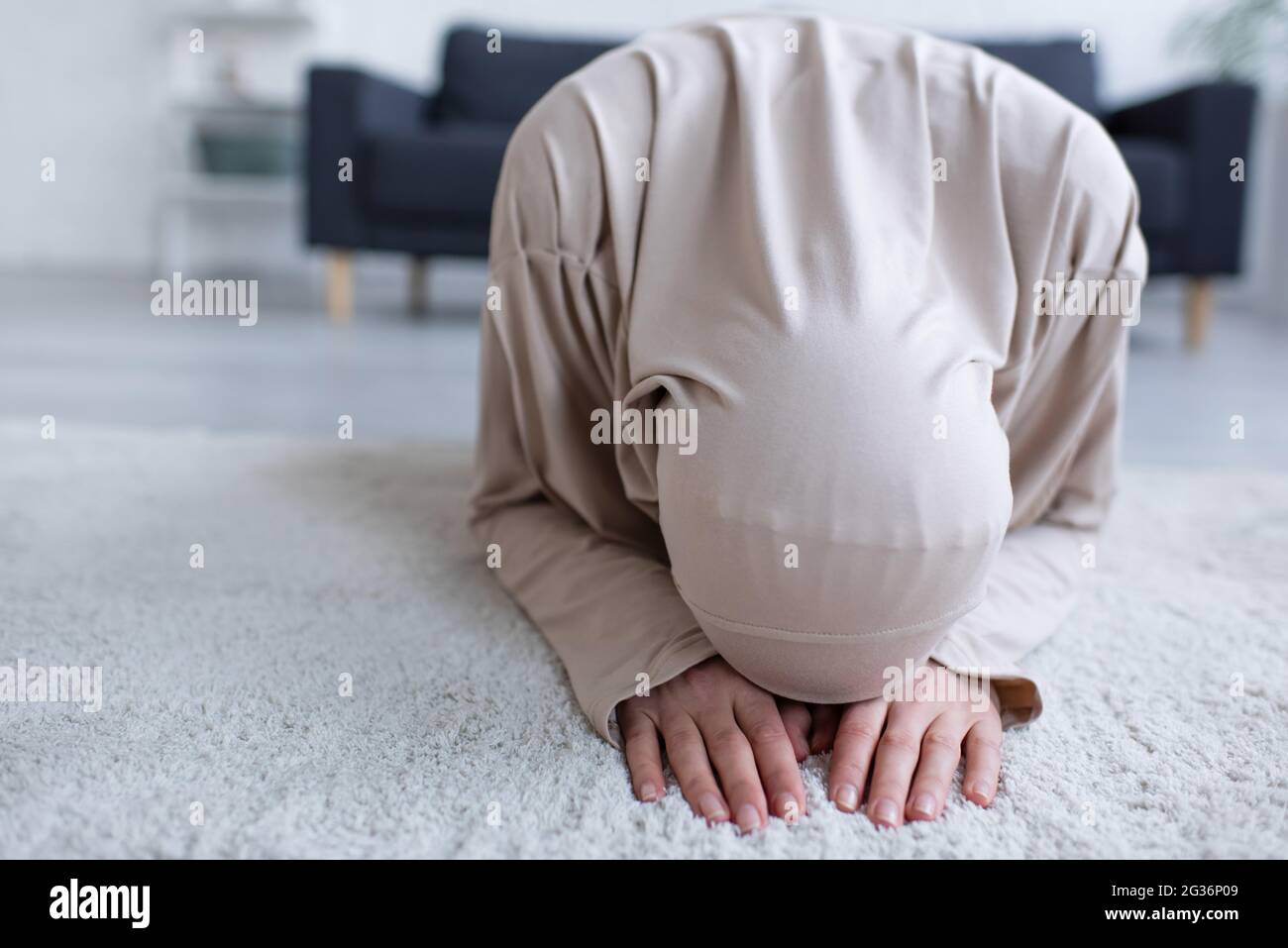 muslim woman with bowed head praying on floor at home Stock Photo - Alamy
