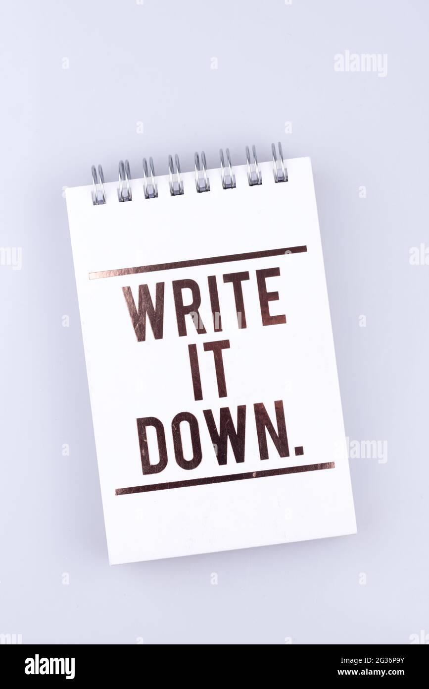 Vertical shot of a notepad with the text "write it down" isolated on a ...