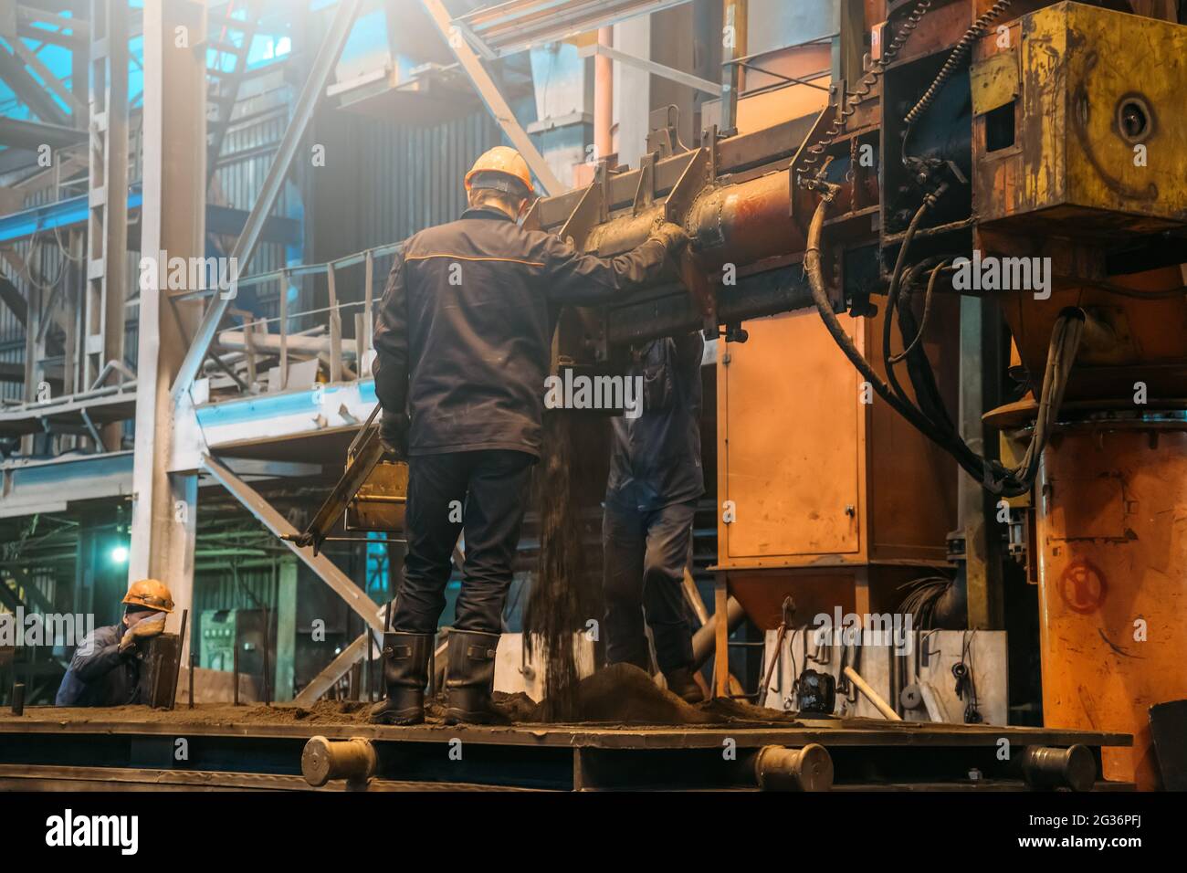 Workers work with molds for smelting iron at steel mill in factory ...