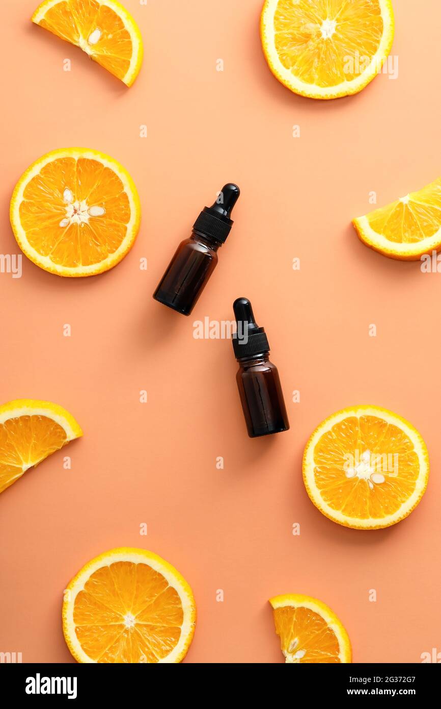 Vitamin C serum dropper bottles with sliced orange top view. Natural ...