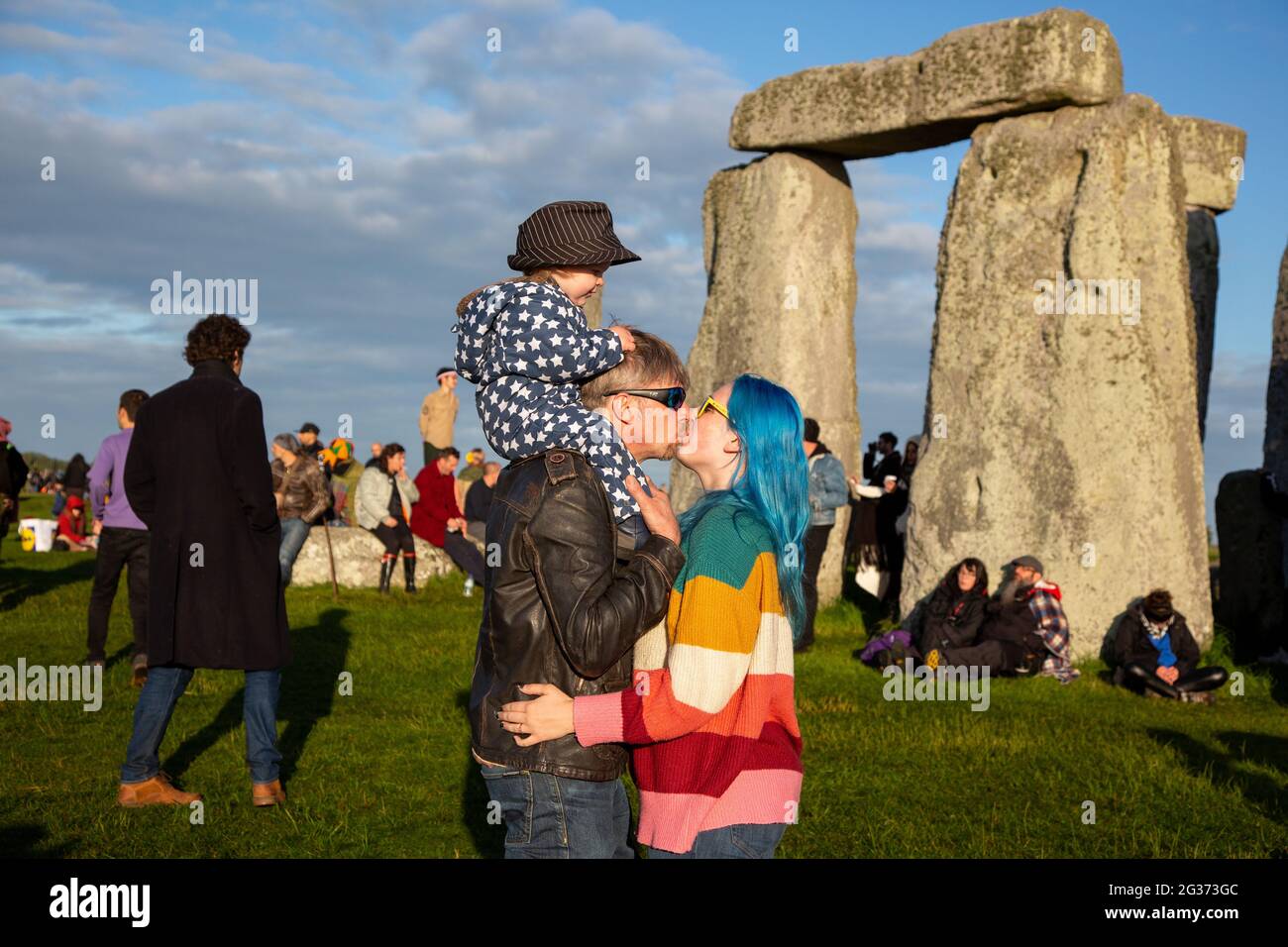 A kissing couple with their child at the summer solstice celebrations ...