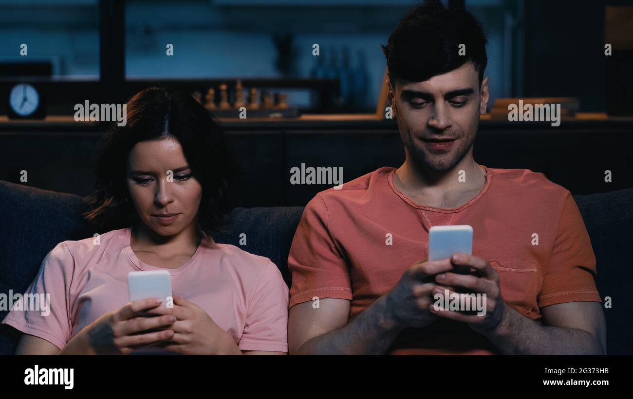 man and woman texting on cellphones in modern living room Stock Photo ...