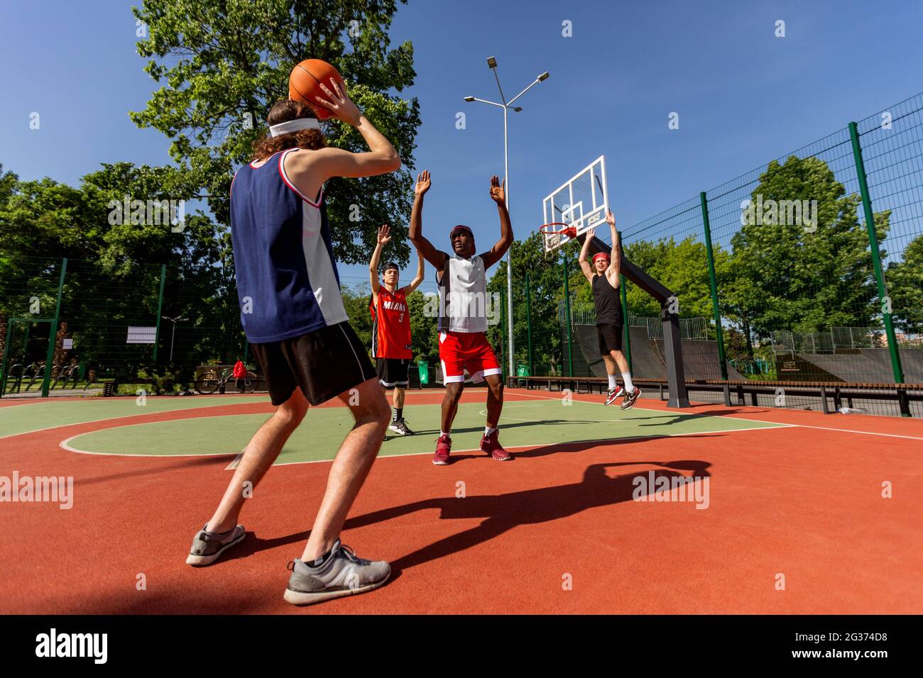Group of young multiracial basketball players having friendly game at ...