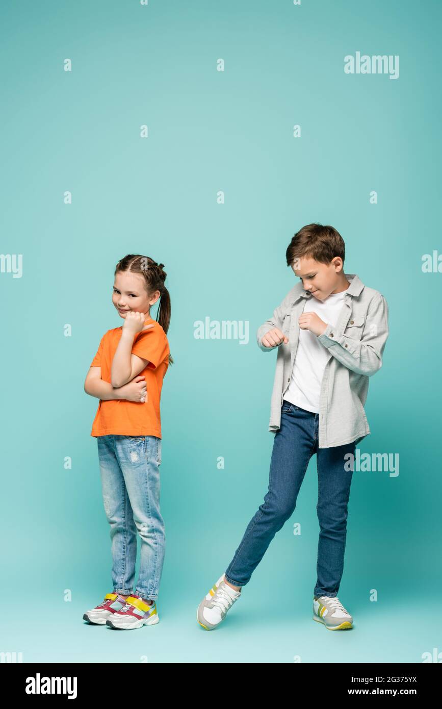 shy girl standing near boy dancing on blue Stock Photo - Alamy
