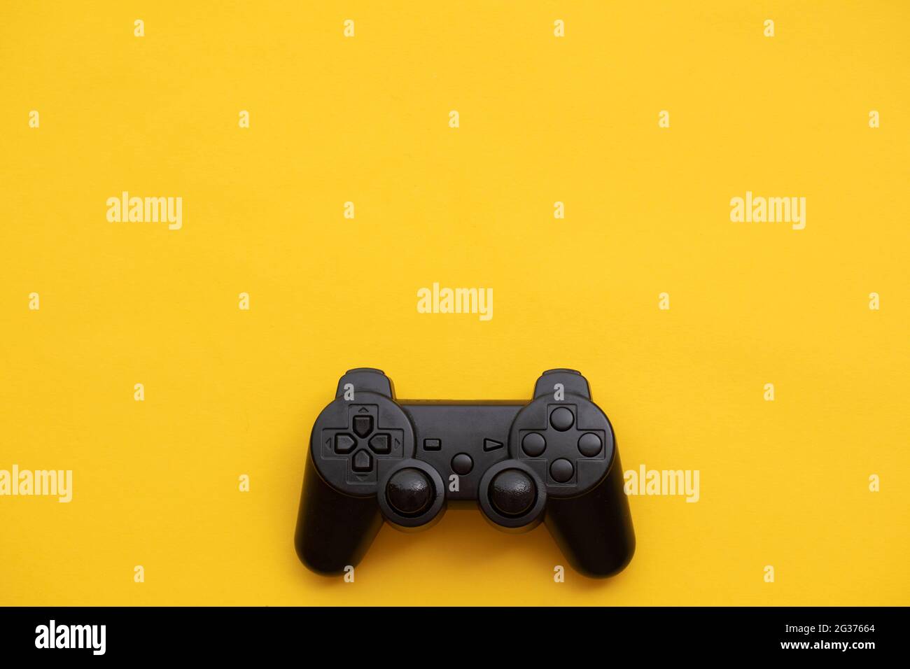 Black video game controller on a bright yellow background Stock Photo ...
