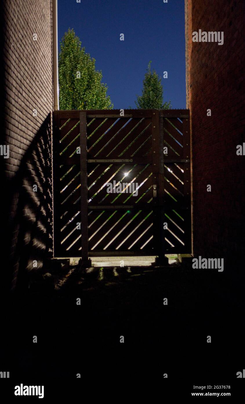 Wooden fence at night securing an alley on a street in a city Stock ...