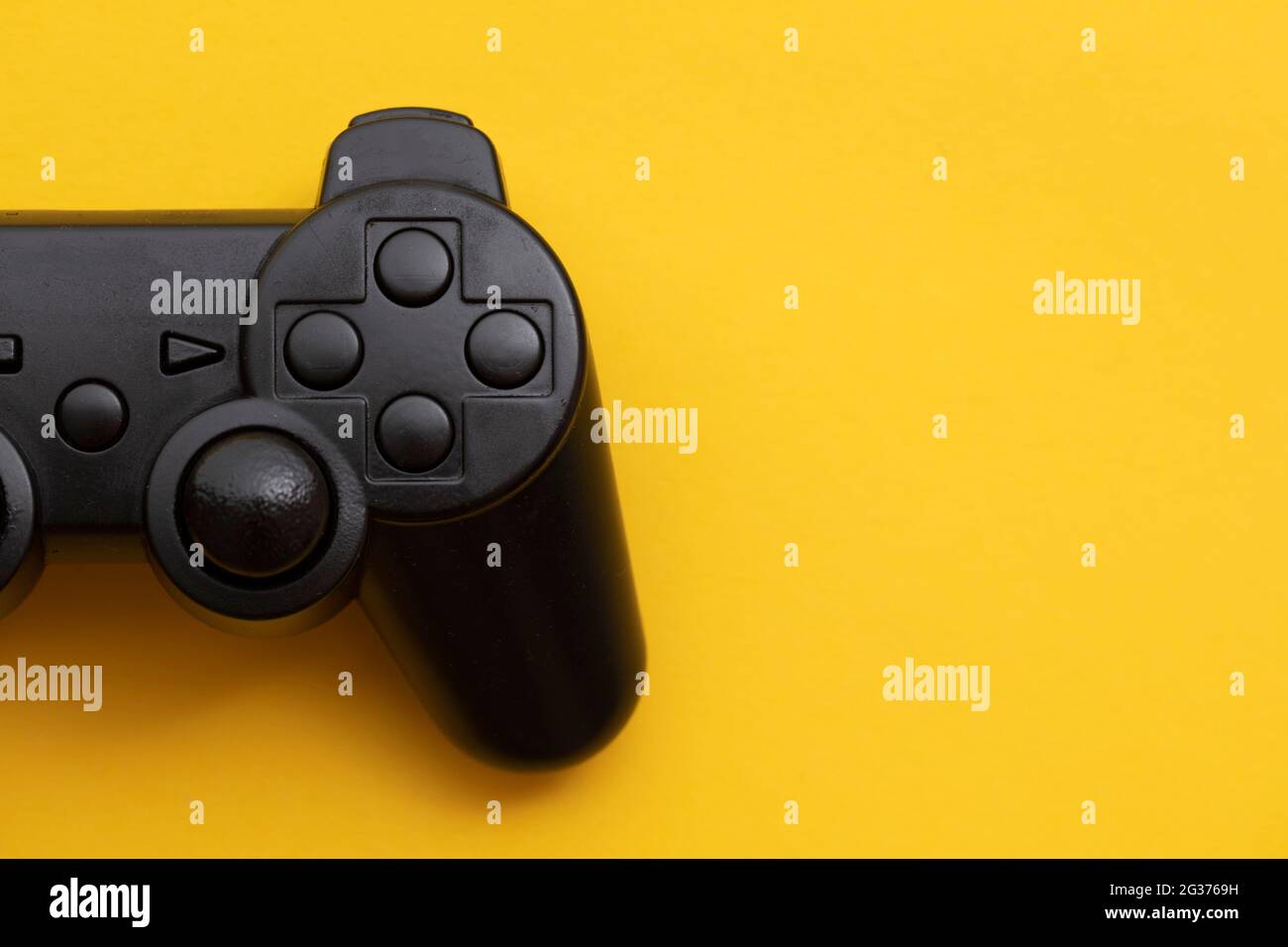 Black video game controller on a bright yellow background Stock Photo ...