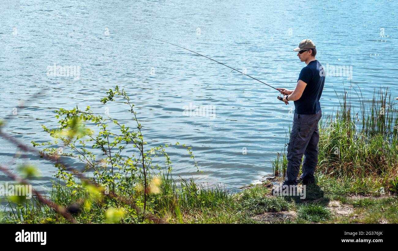 Fisherman with spinning rod on nature background. Angler man with ...