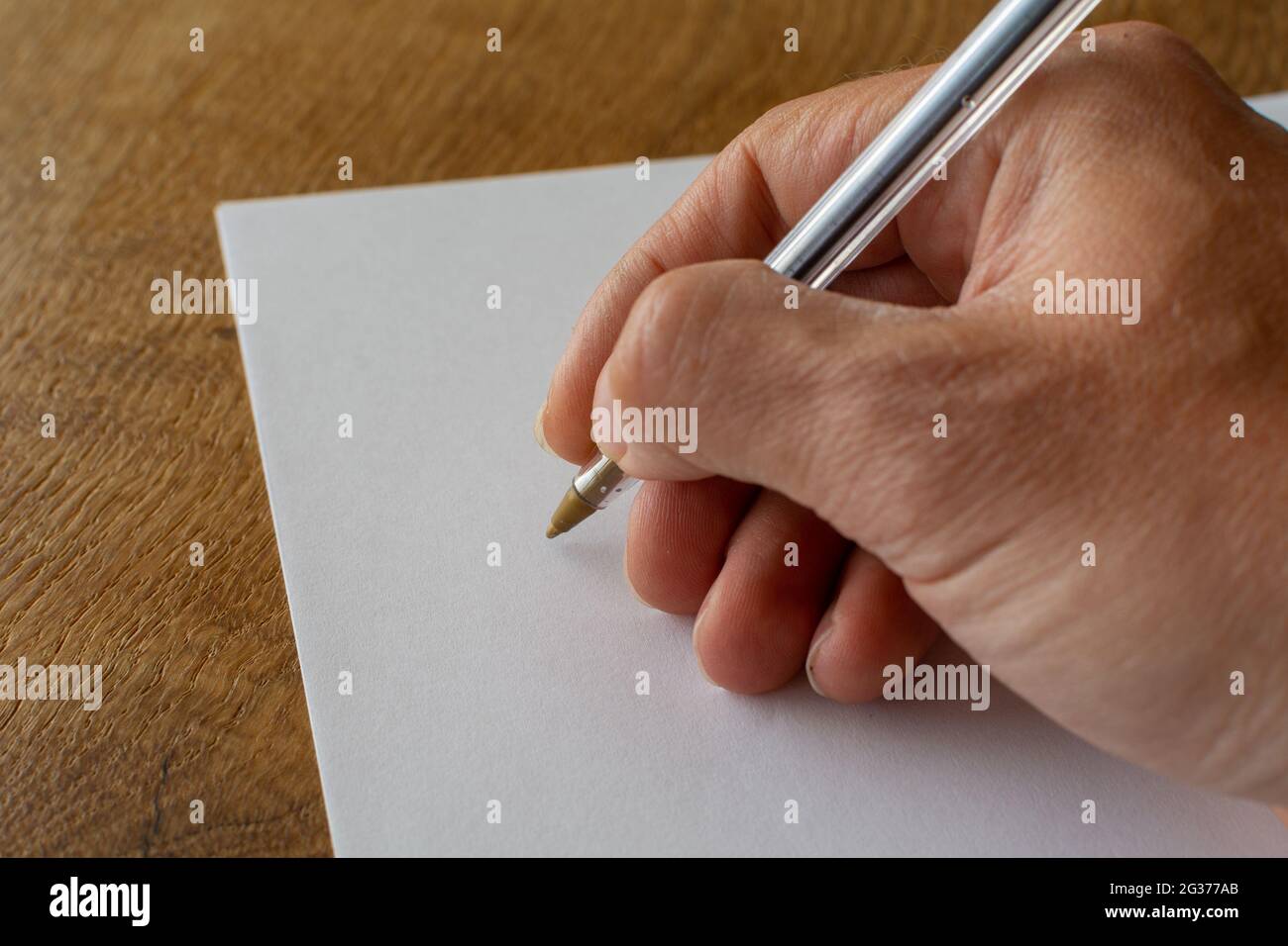 Male hand with pen writing on a blank sheet of paper Stock Photo - Alamy