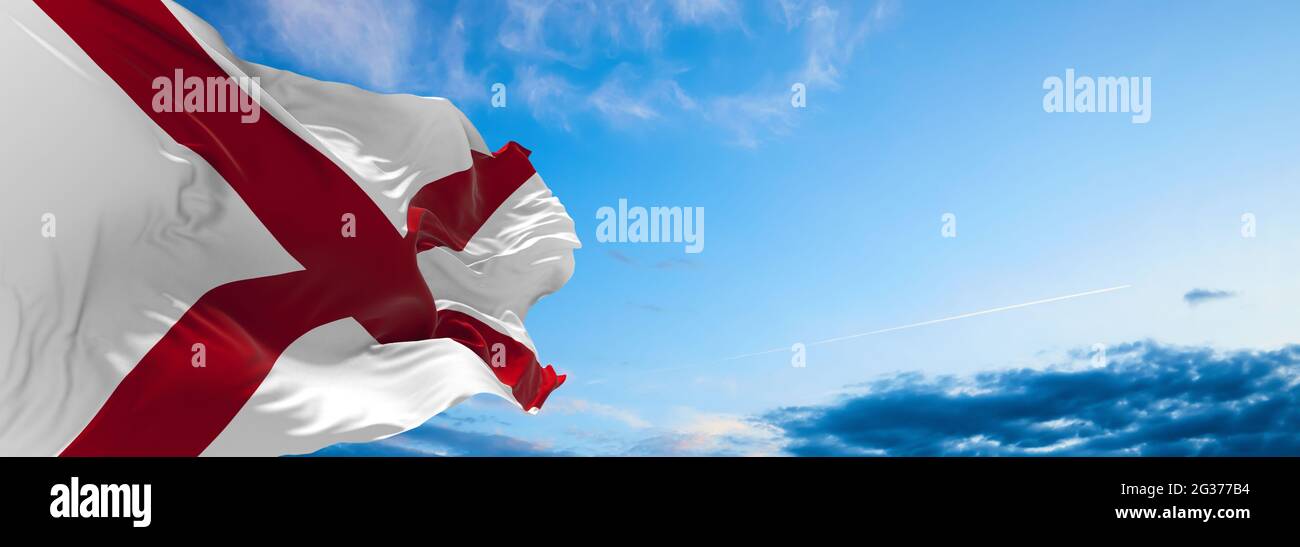 flag of Alabama at cloudy sky background on sunset. Patriotic concept ...