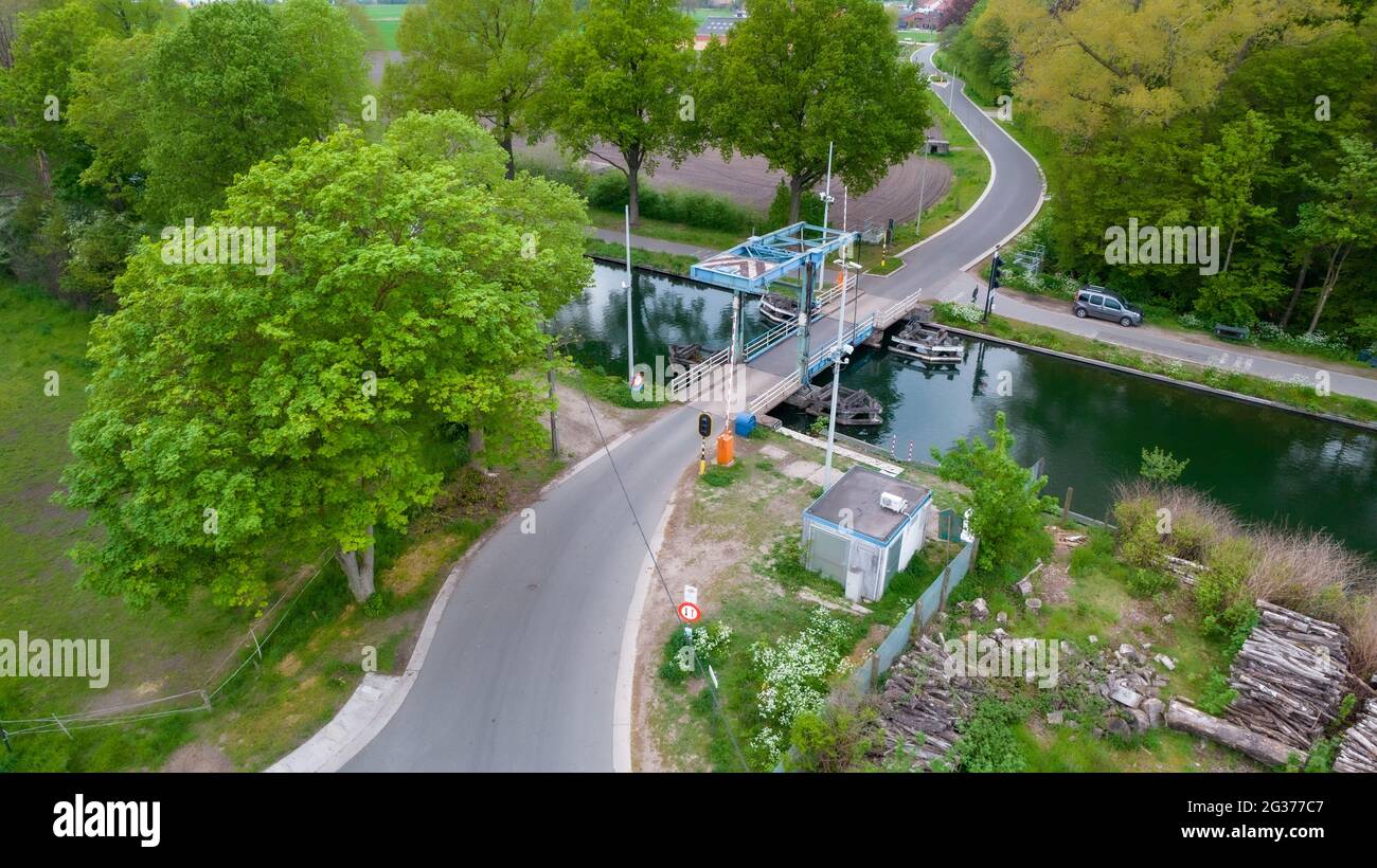 aerial shot of a drawbridge over a canal or river in a green ...