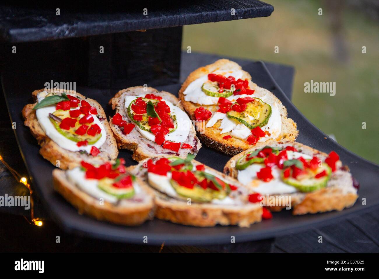 Roasted vegetable bruschetta served on a black plate Stock Photo - Alamy