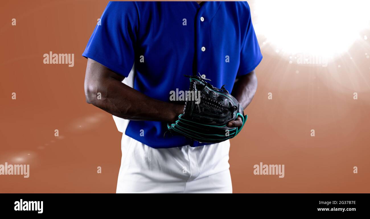 Mid section of african american male baseball pitcher against spot of ...