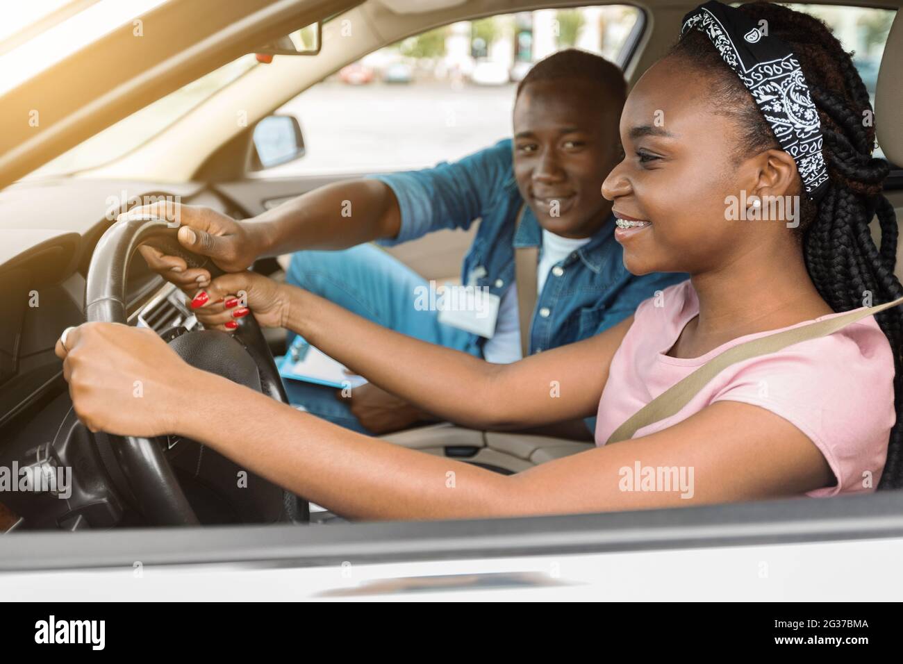 Happy african american woman attending driving school, driving with ...