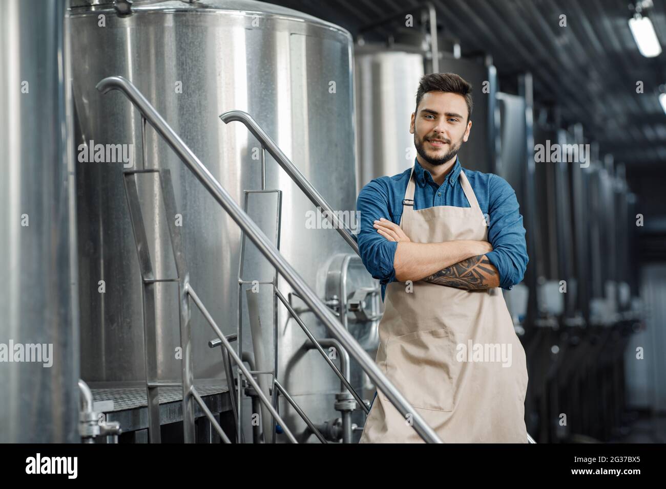Brewer with large metal container at brewery factory Stock Photo - Alamy