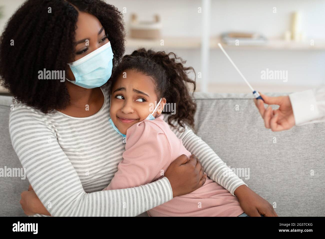 Doctor taking PCR test sample from scared afro girl Stock Photo - Alamy