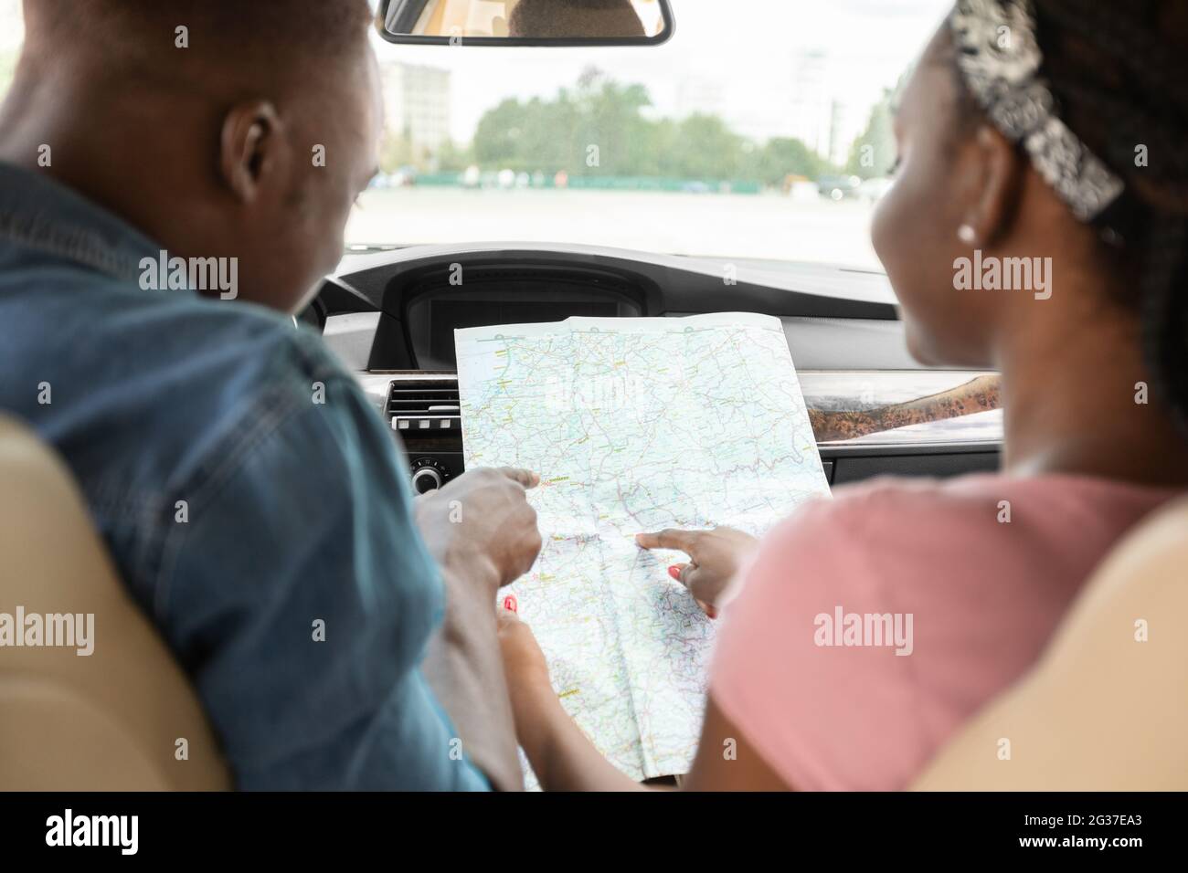 Black couple travellers looking at map while driving, back view Stock ...