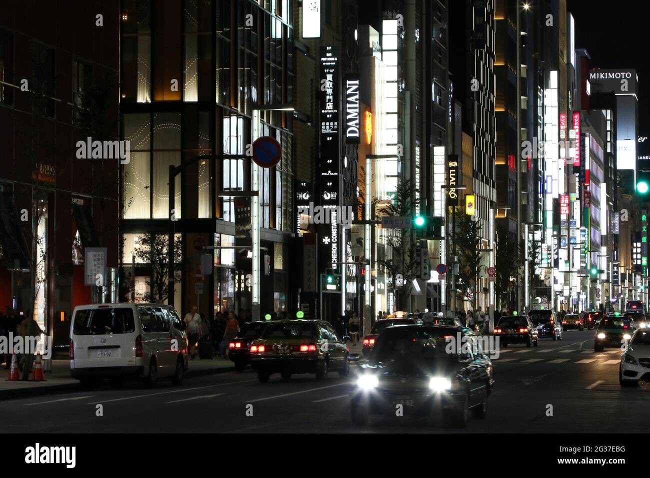 Illuminated street with neon lights and cars in traffic in Ginza ...