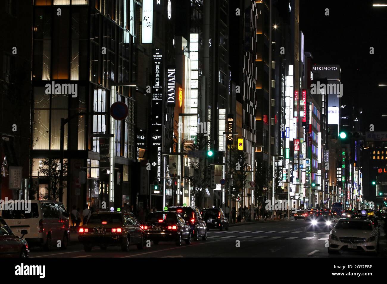 Illuminated street with neon lights and cars in traffic in Ginza ...