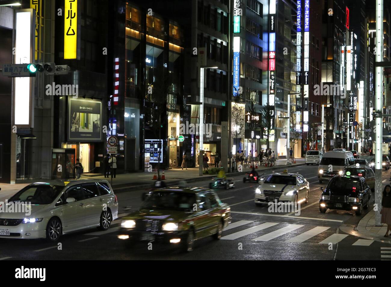 Illuminated street with neon lights and cars in traffic in Ginza ...