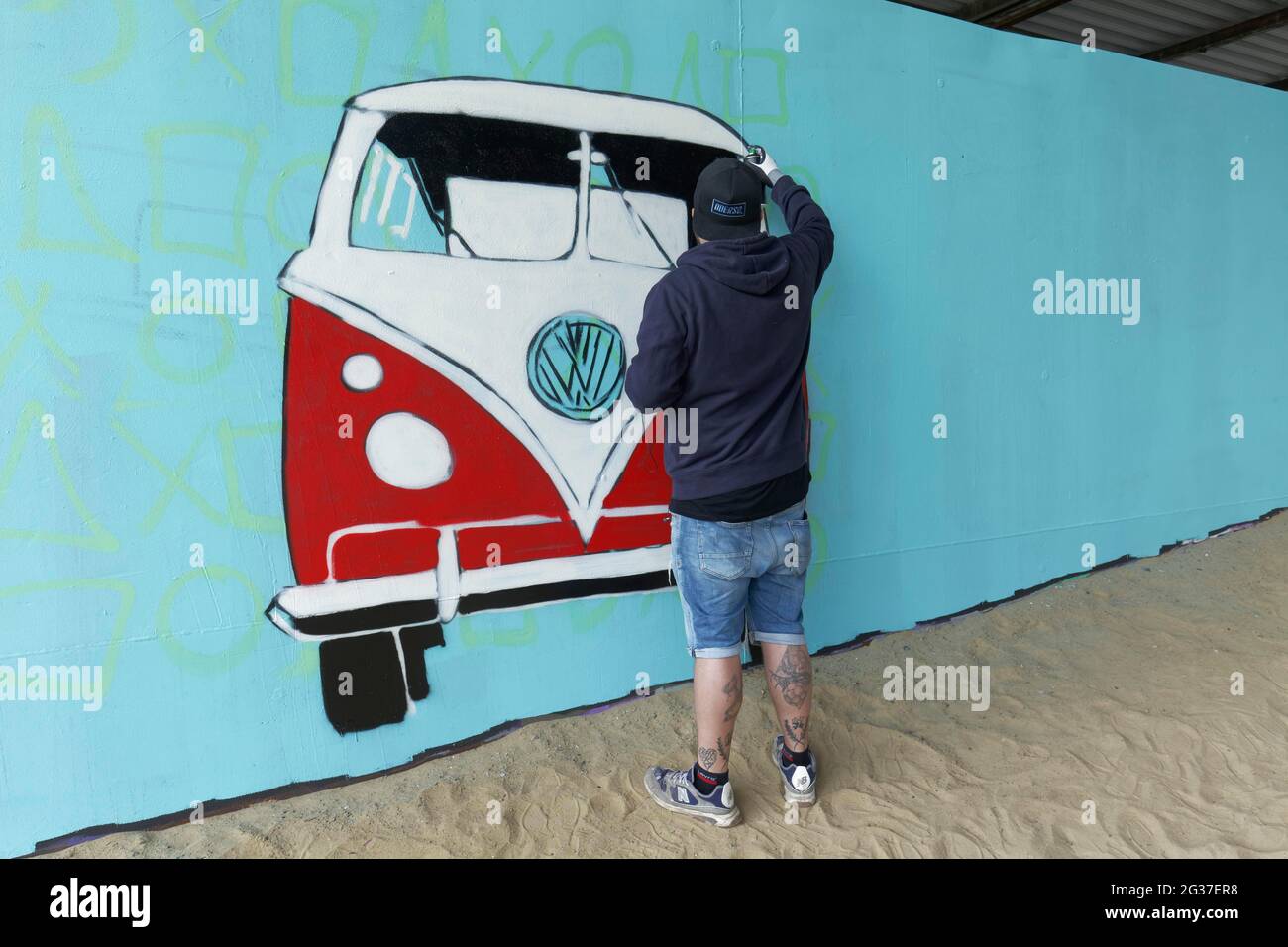 Graffitimaler sprays VW bus, Bulli, on a blue primed wall, Duisburg ...