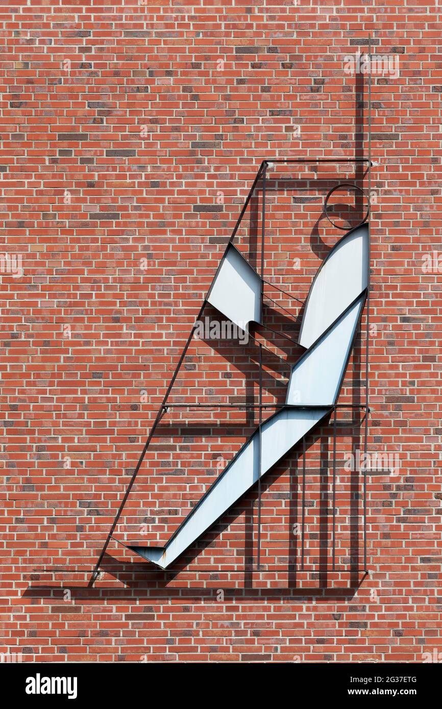 Sitting man reading book, abstract figure made of iron on a brick ...