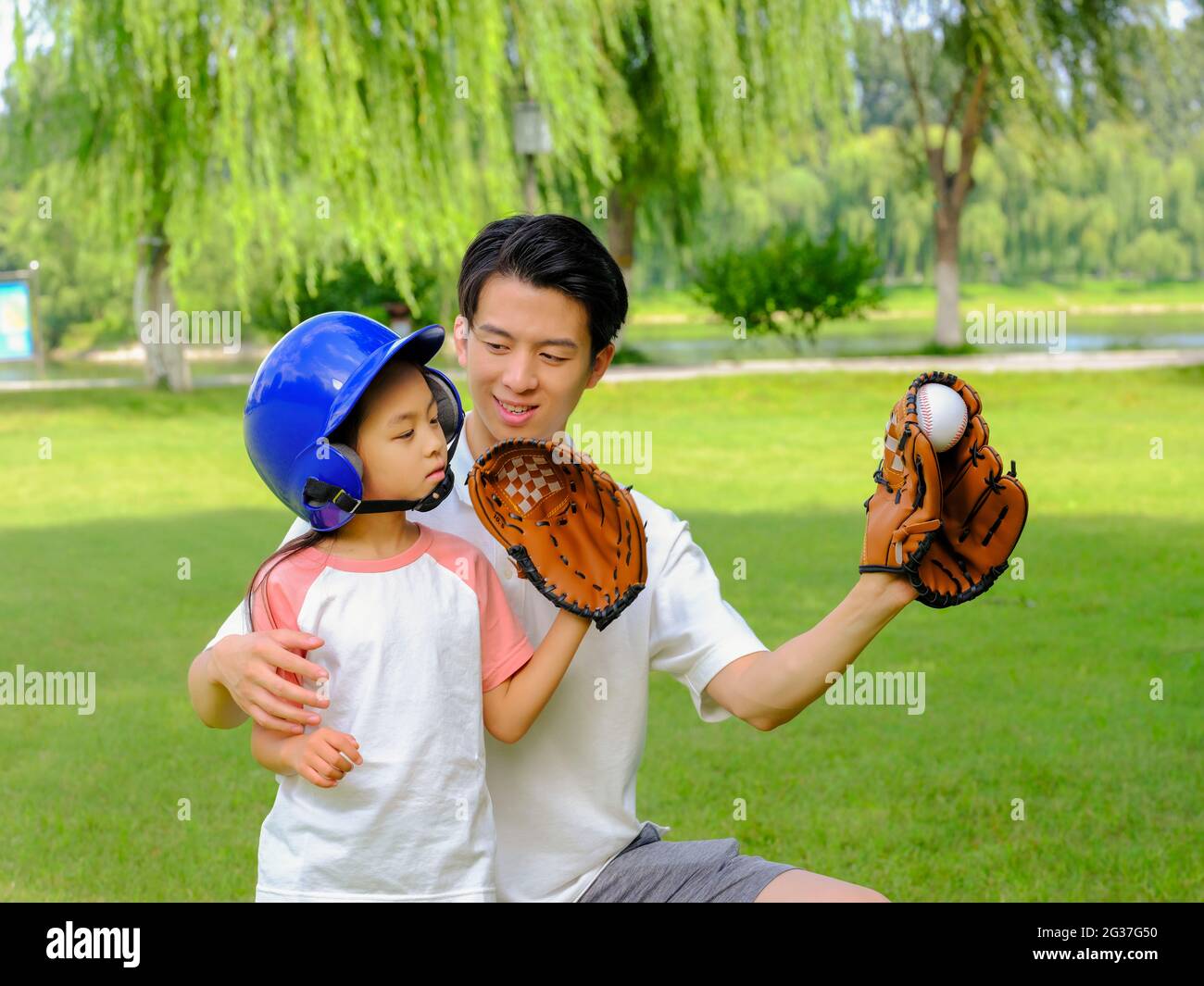 Happy father and daughter are playing baseball in the park high quality ...