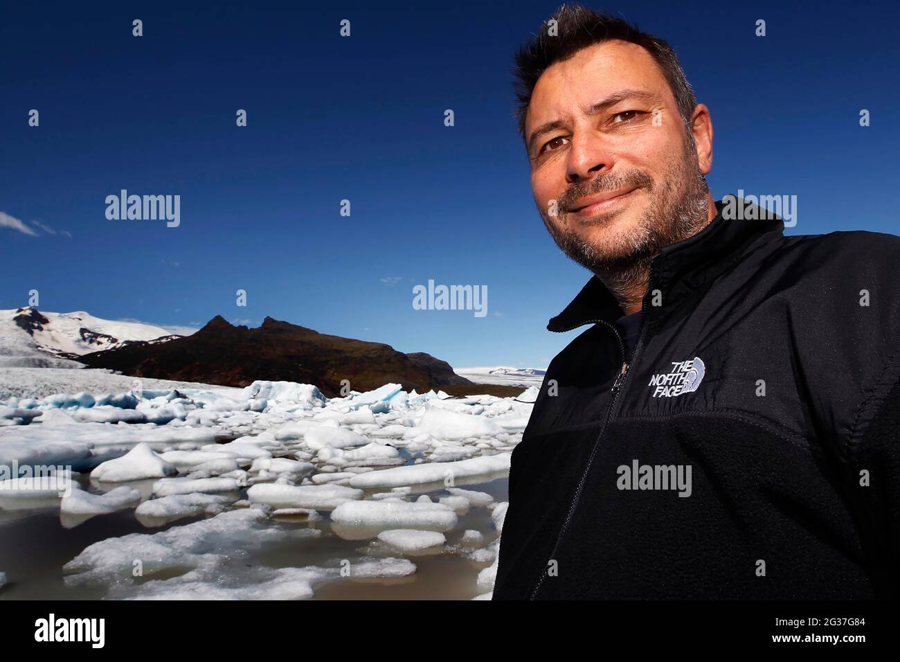 Man in front of icebergs, floating ice chunks, glacier ice, glacier ...