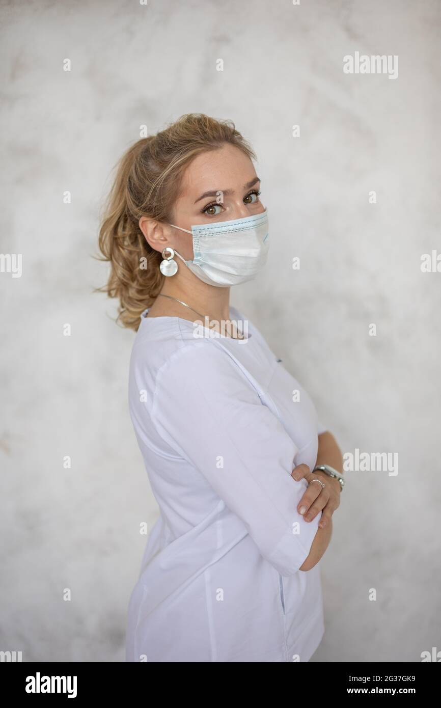 Beautiful female doctor or nurse wearing protective mask and medical ...