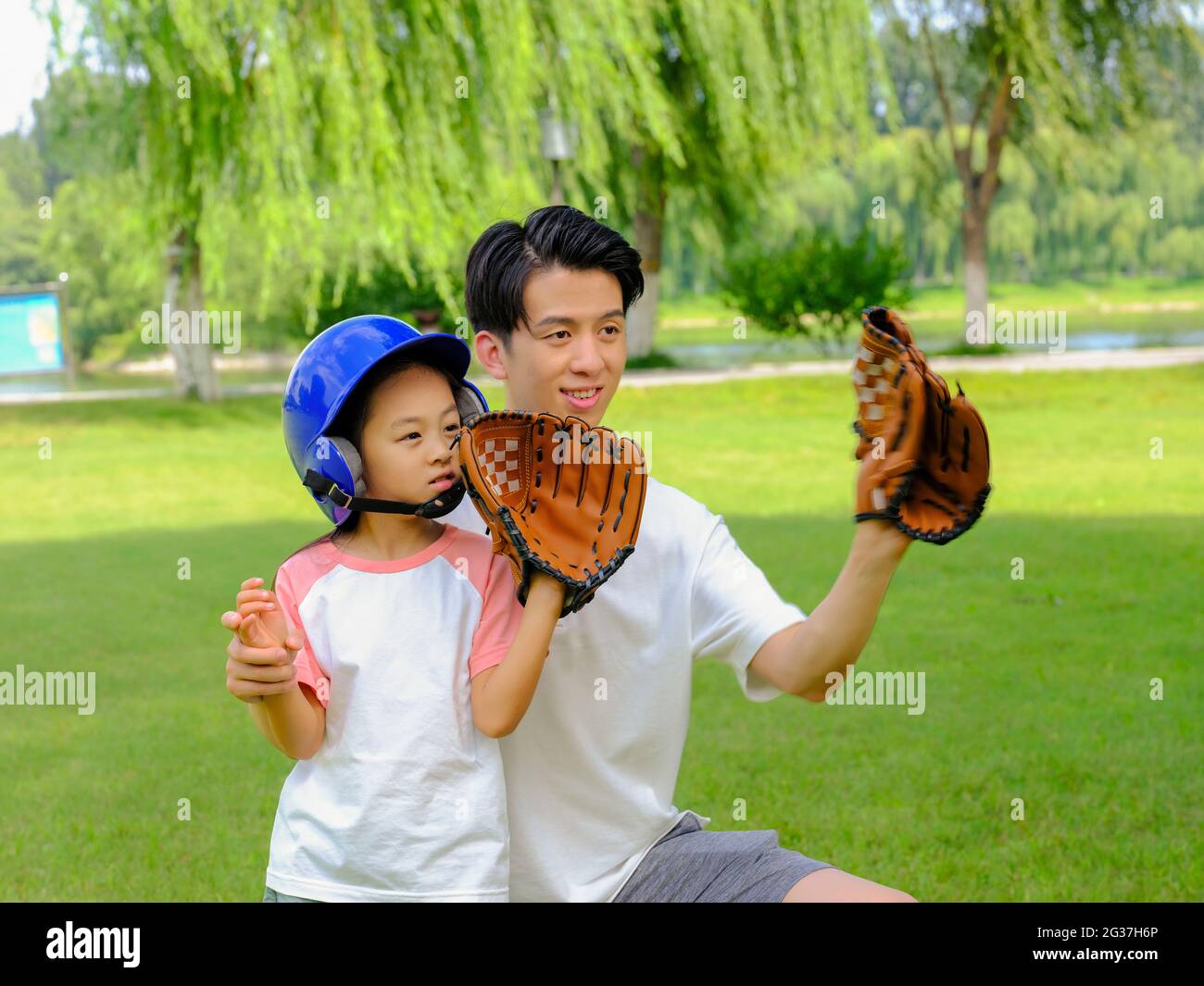 Happy father and daughter are playing baseball in the park high quality ...