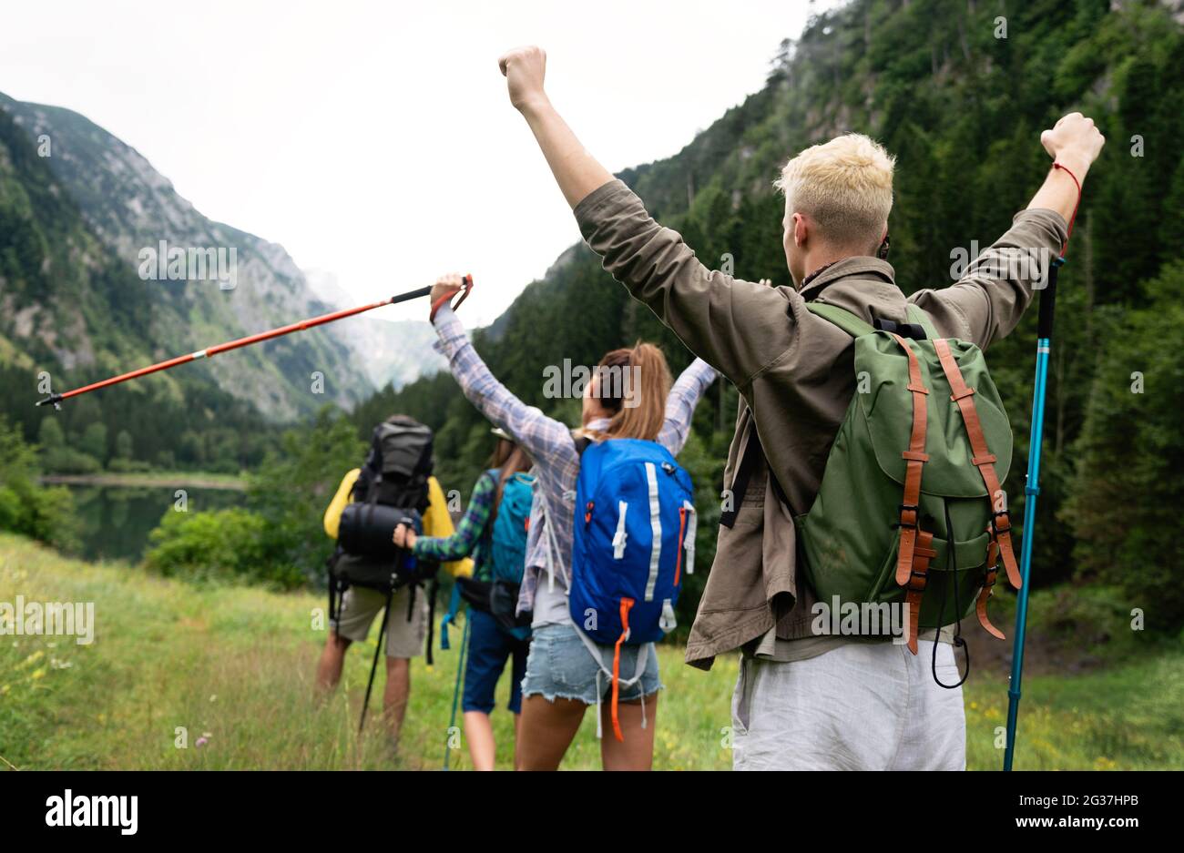 Group of friends hiking together outdoors exploring the wilderness and ...