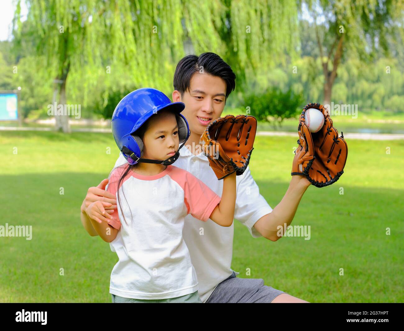 Happy father and daughter are playing baseball in the park high quality ...