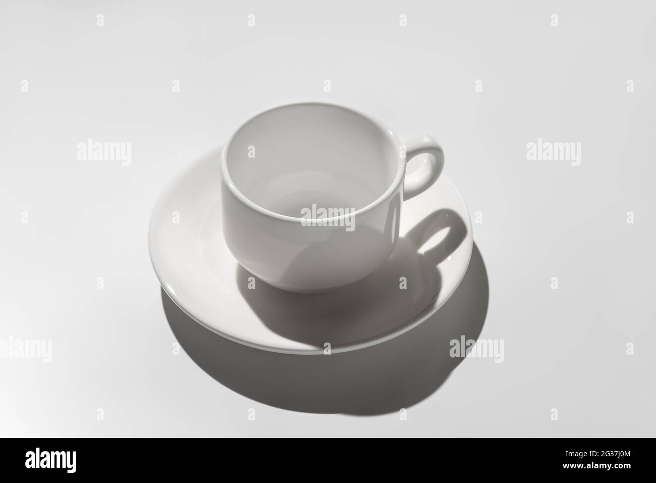 empty white coffee cup. hard shadows on gray background Stock Photo - Alamy